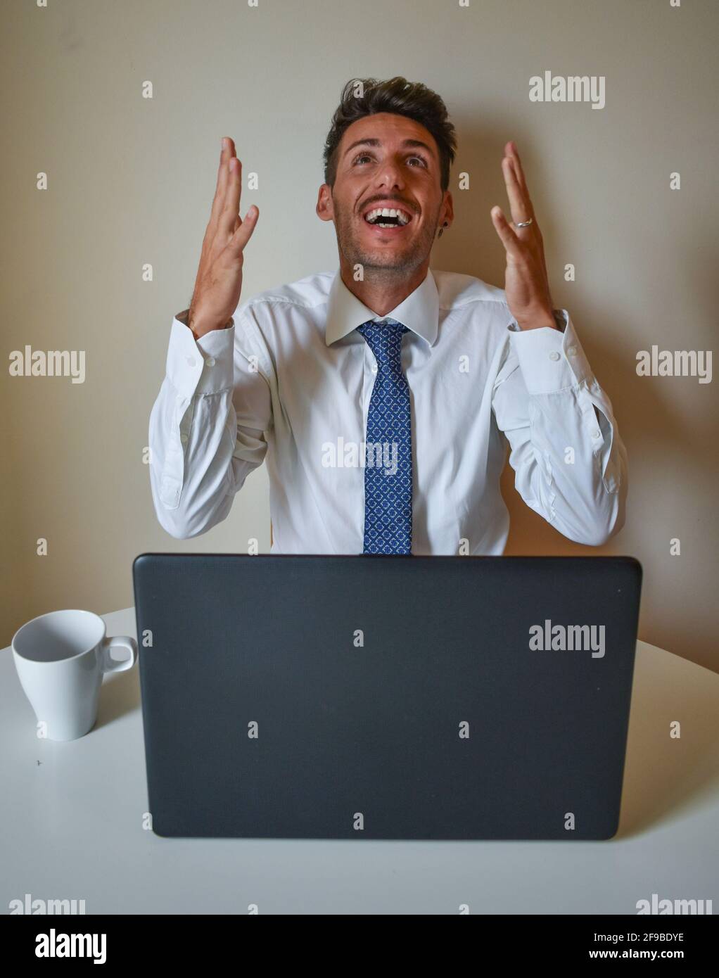 Spanish businessman showing a successful gesture in front of his laptop ...