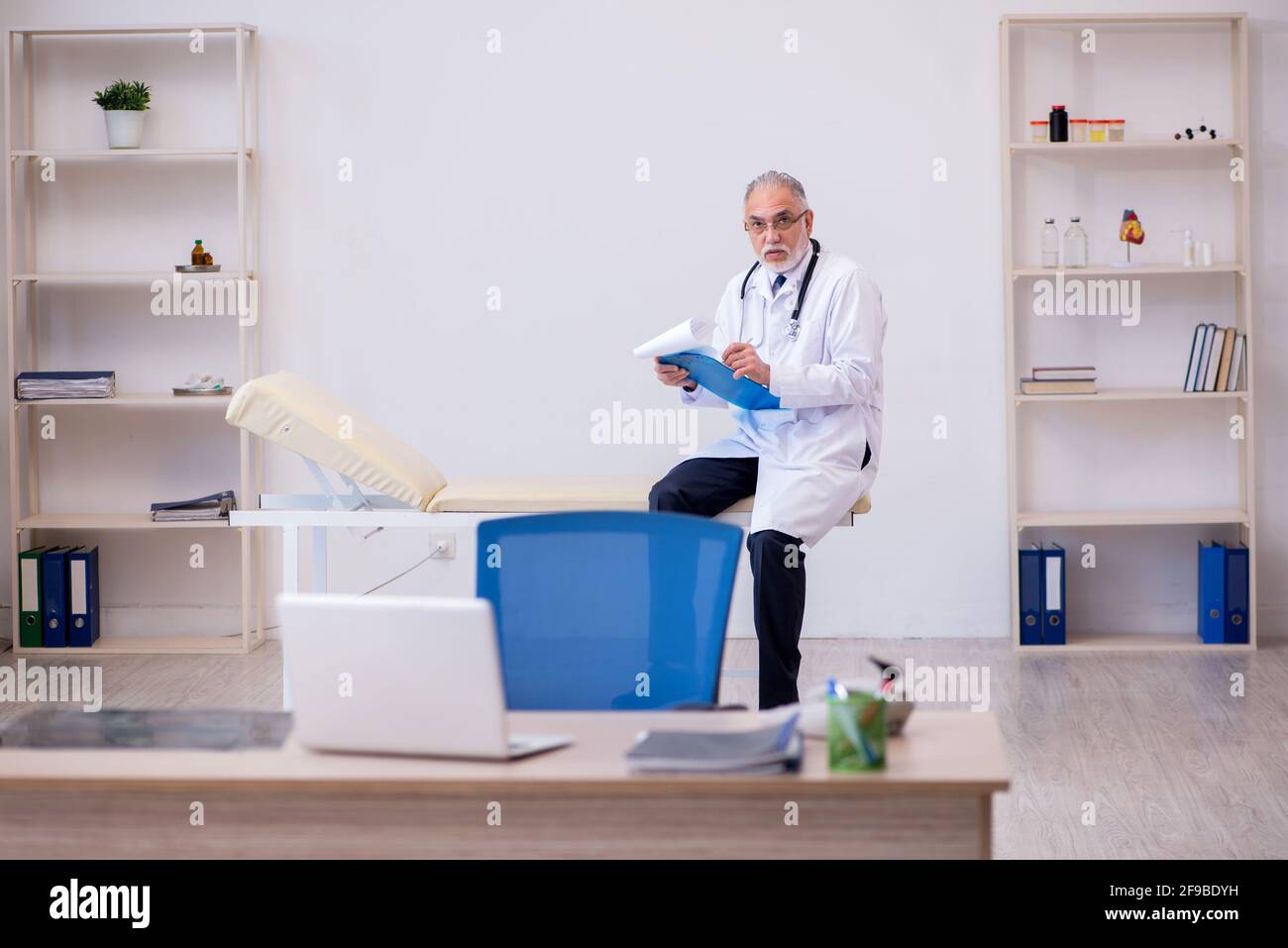 Old male doctor working in the hospital Stock Photo - Alamy