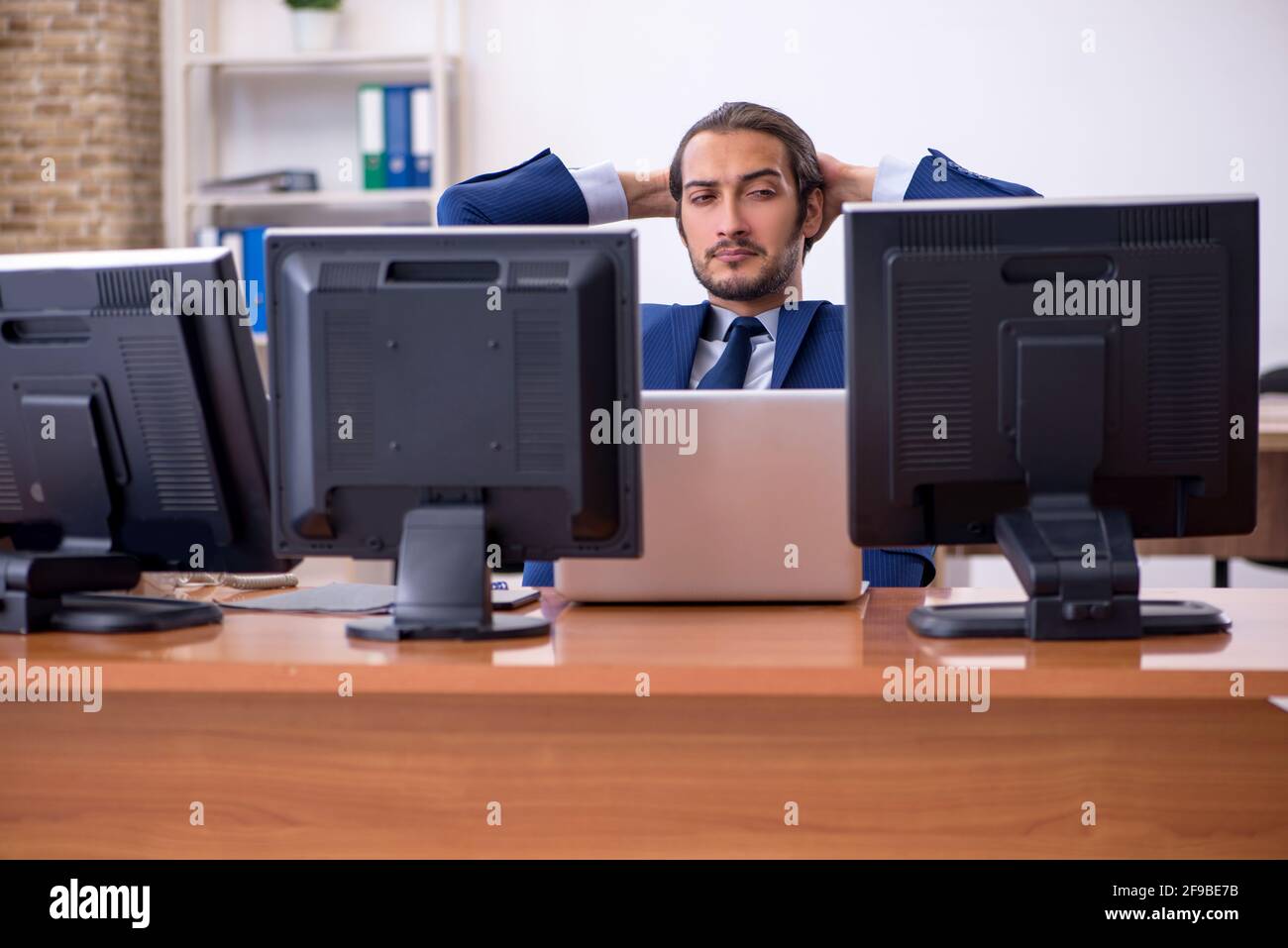 Young employee in multitasking concept Stock Photo - Alamy