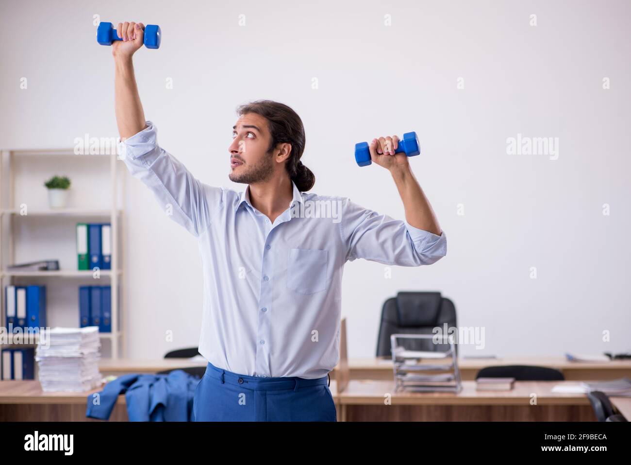 Young employee doing sport exercises during break Stock Photo - Alamy