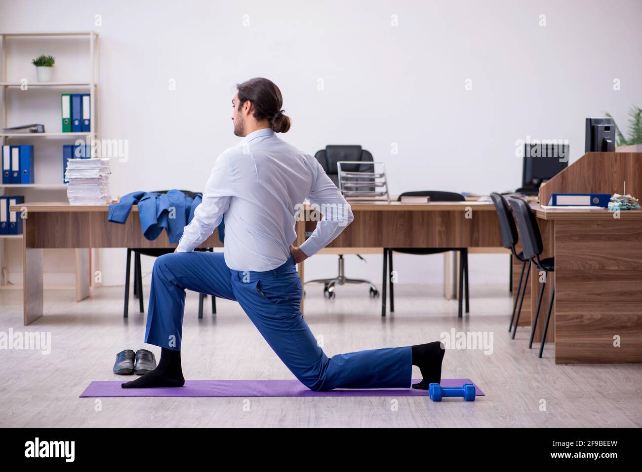 Young employee doing sport exercises during break Stock Photo - Alamy
