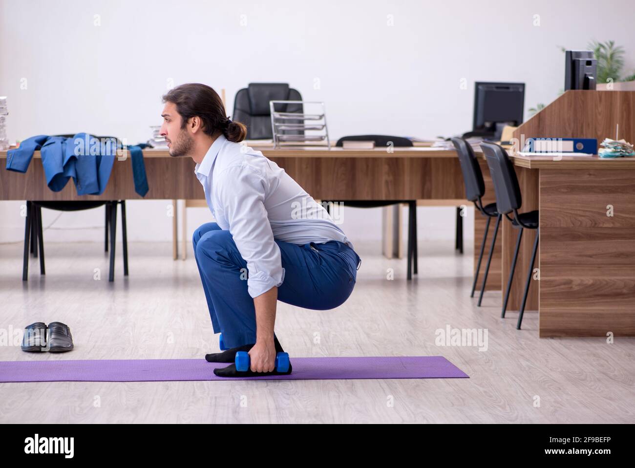 Young employee doing sport exercises during break Stock Photo - Alamy