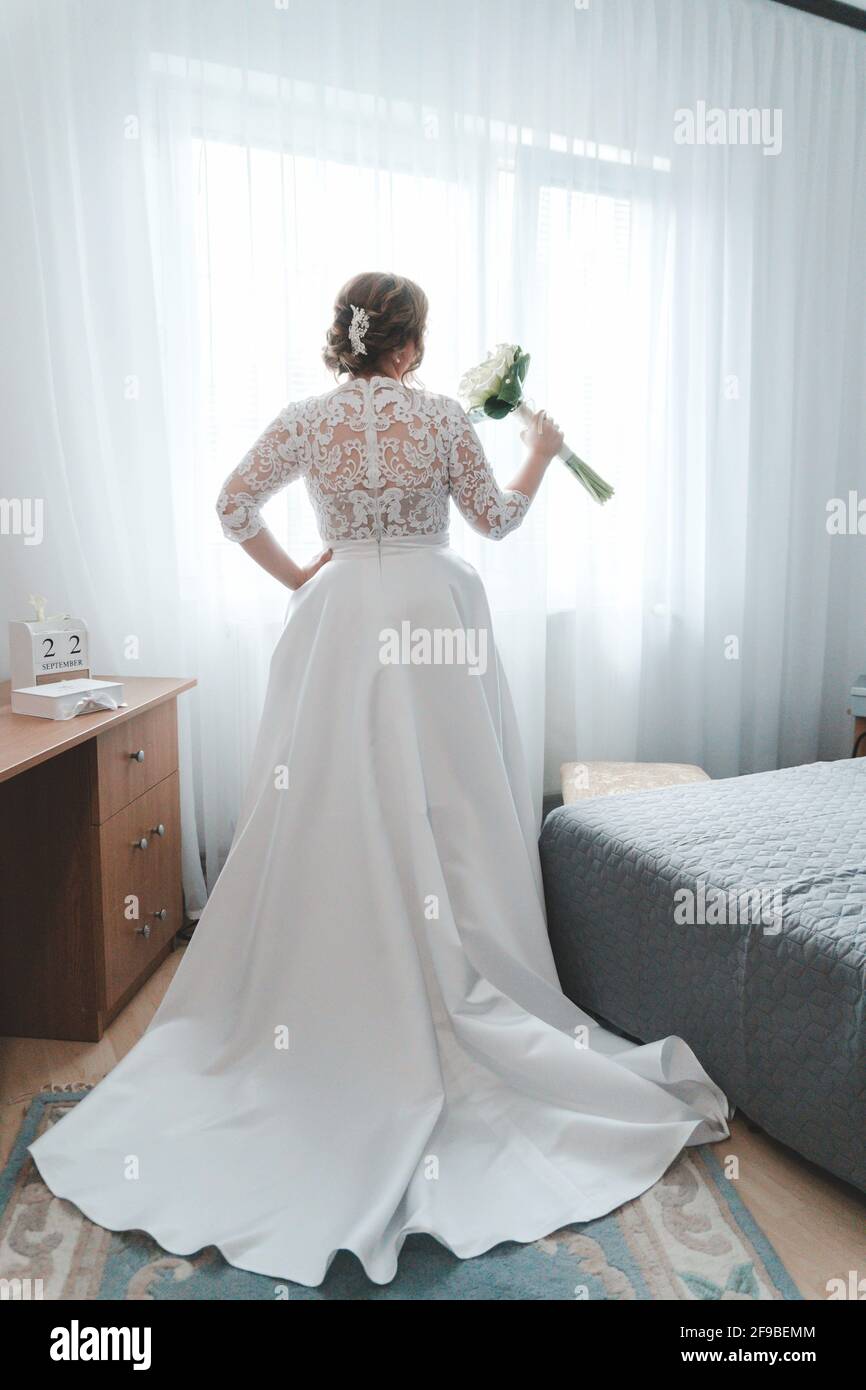 Vertical back view of a bride holding a bouquet Stock Photo - Alamy