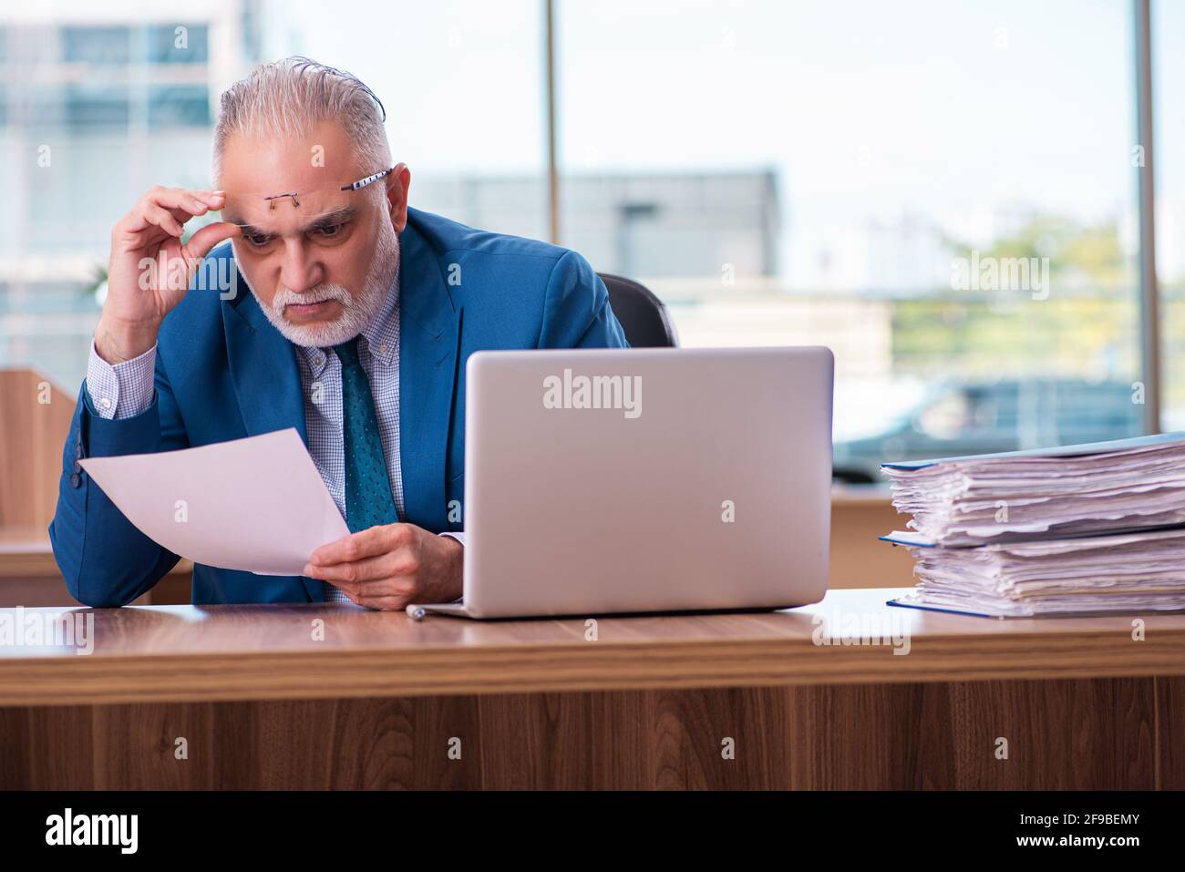 Old employee working in the office Stock Photo - Alamy