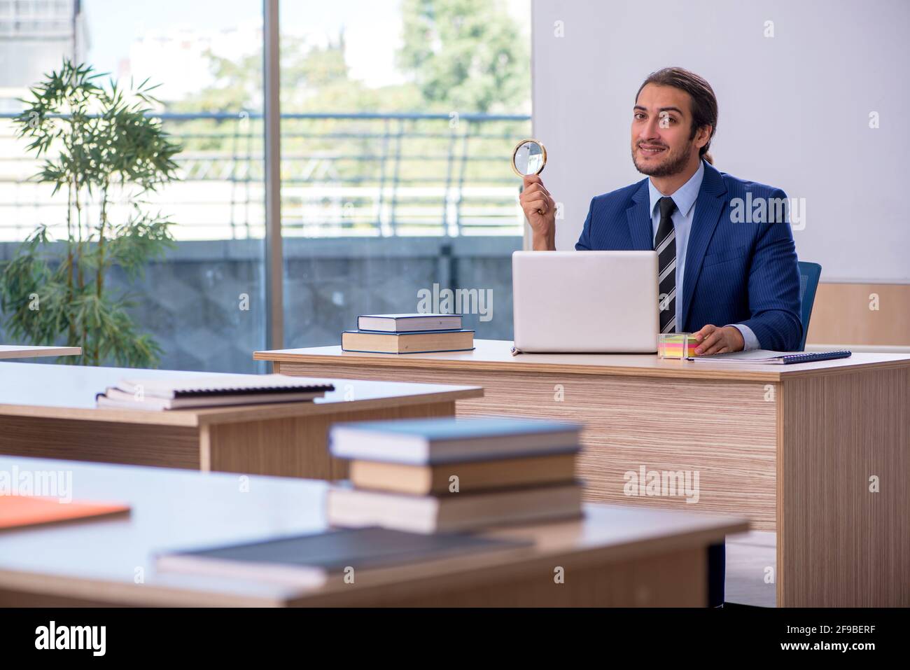 Young teacher in suit in the classroom Stock Photo - Alamy
