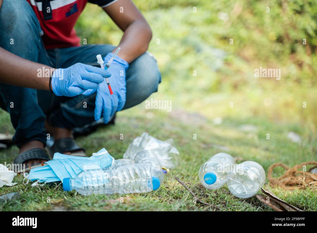 unrecognizable volunteer or waste collector busy sepereating and ...
