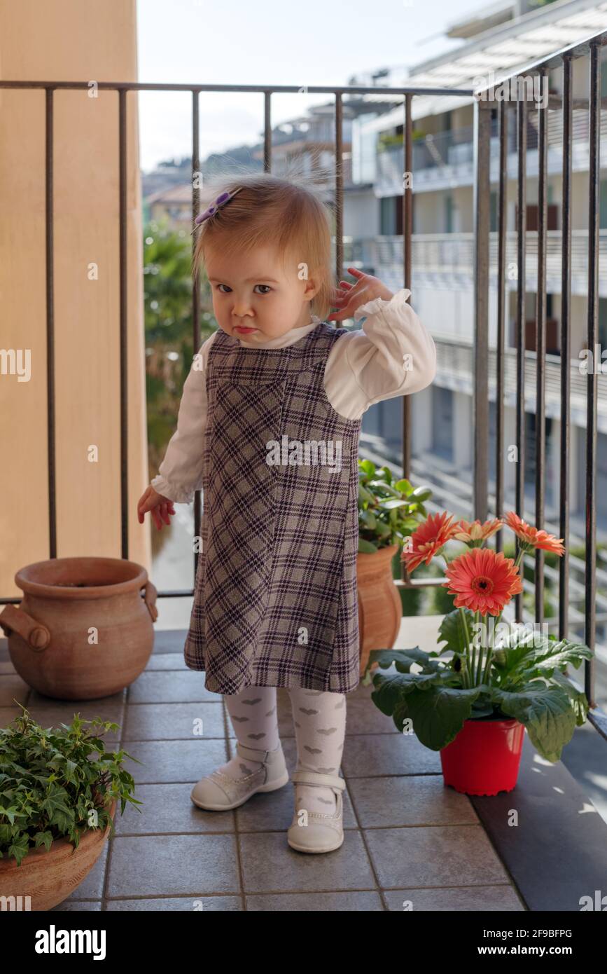 Girl standing by a railing of the balcony Stock Photo - Alamy