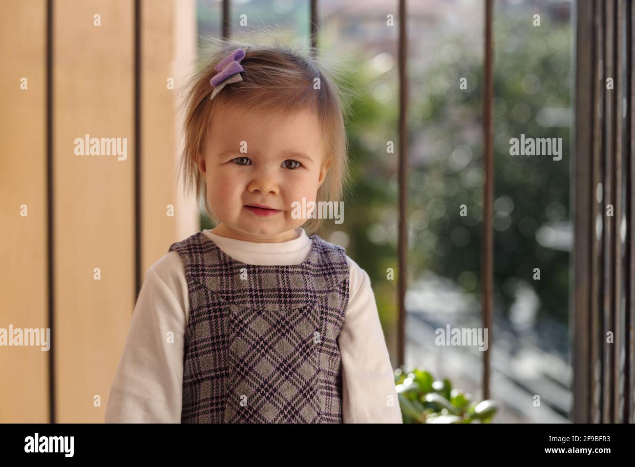 Girl standing by a railing of the balcony Stock Photo - Alamy