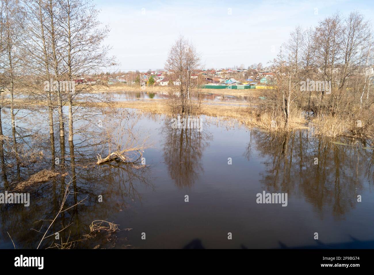 Spring landscape with flood in rural terrain on background blue sky ...