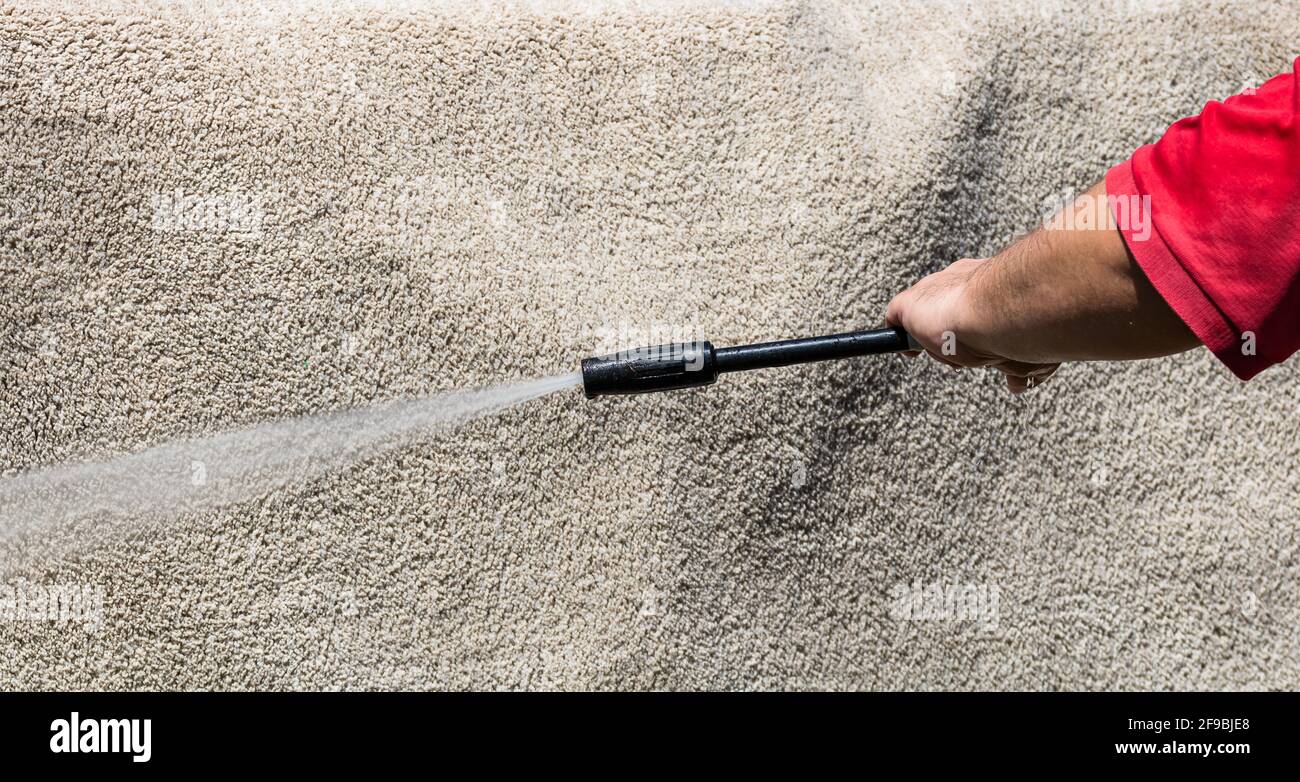 Cleaning the carpet with a gun for washing high pressure water. House ...