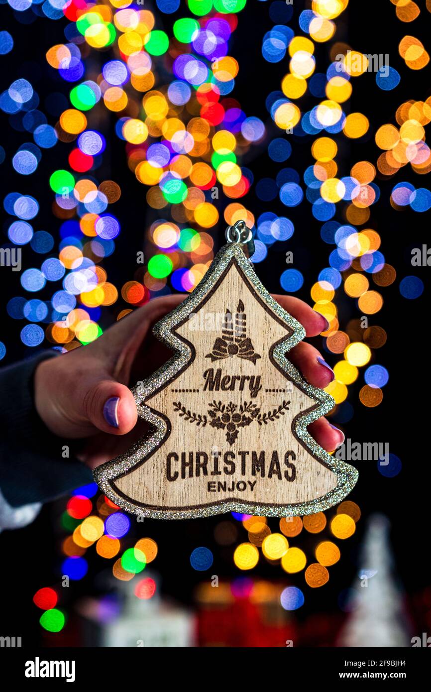 Woman holding a wooden Christmas decoration on background with blurred ...