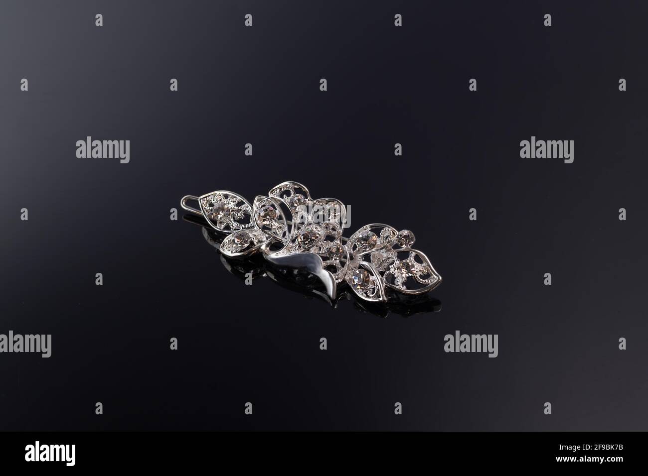 Bijouterie and jewelry on a dark background. Brooches and hairpins ...