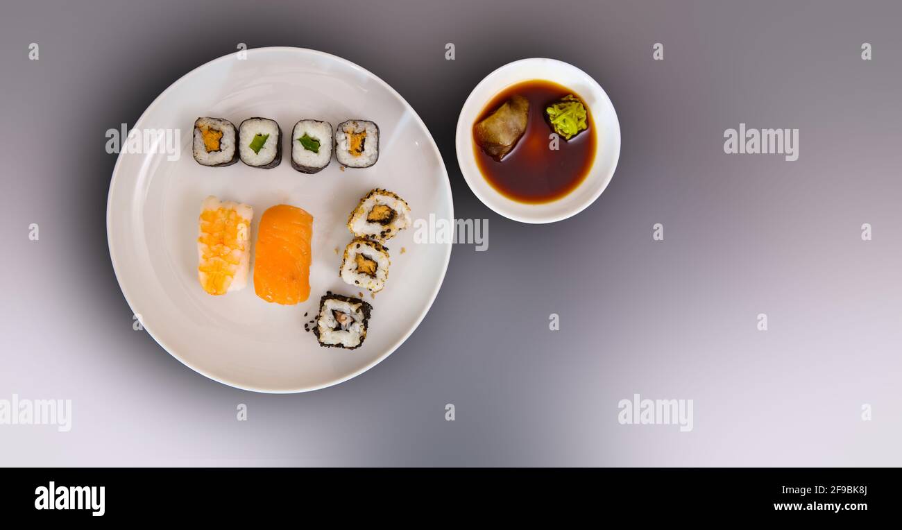 Set of sushi on grey background on white plates Stock Photo - Alamy