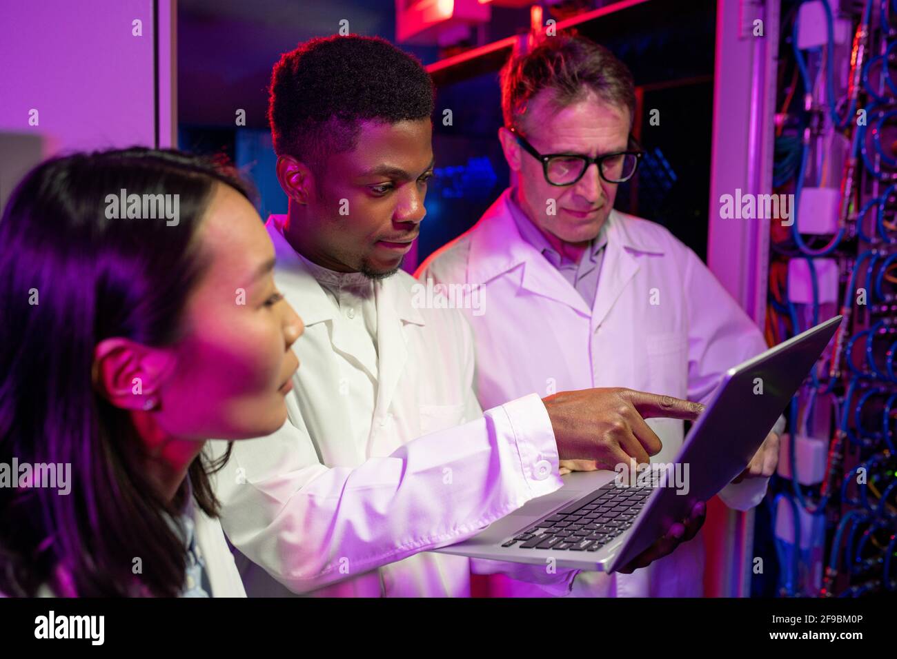 Group of concentrated modern multi-ethnic server specialists in lab ...