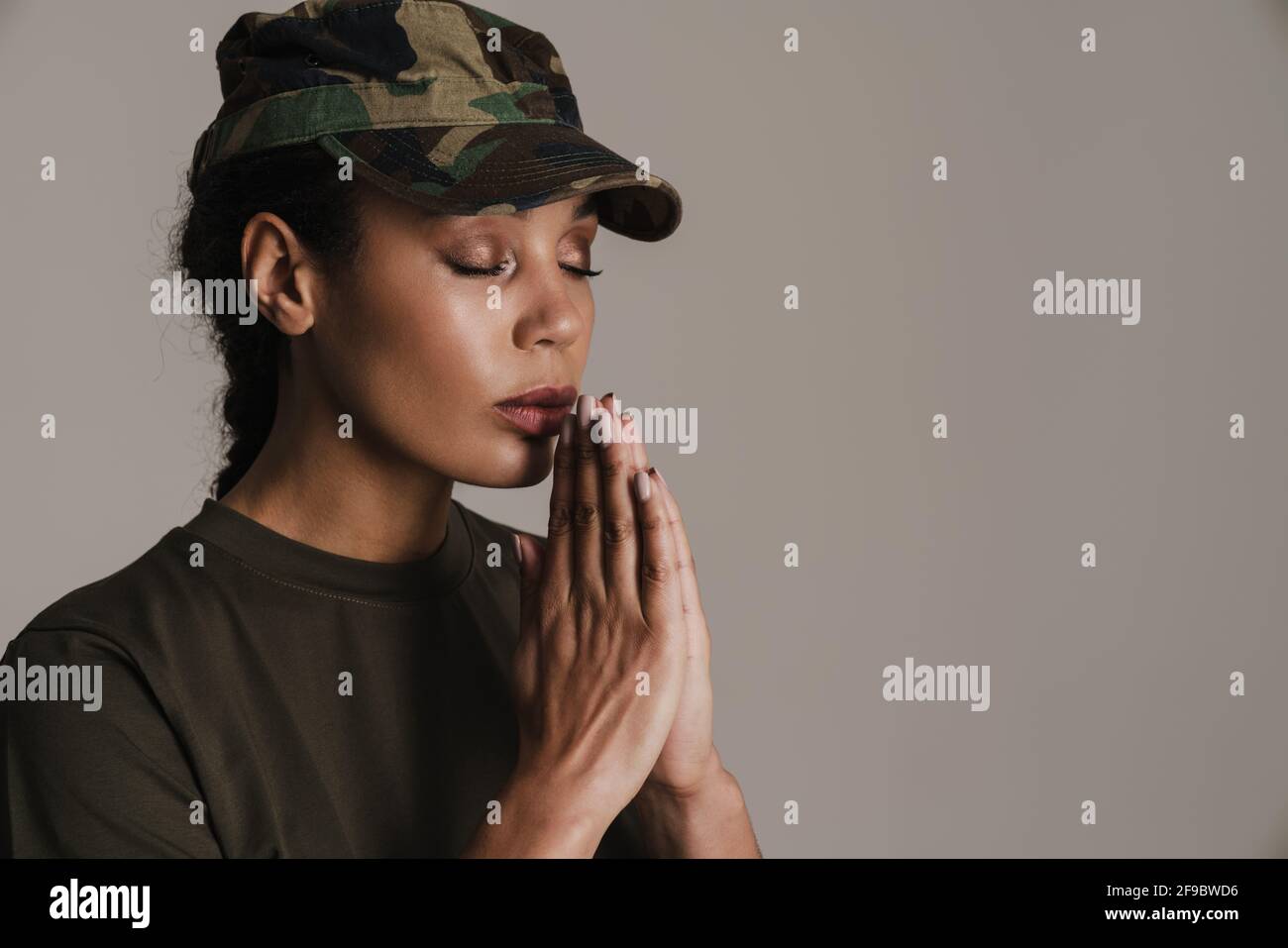 Calm african american soldier woman holding palms together while posing ...