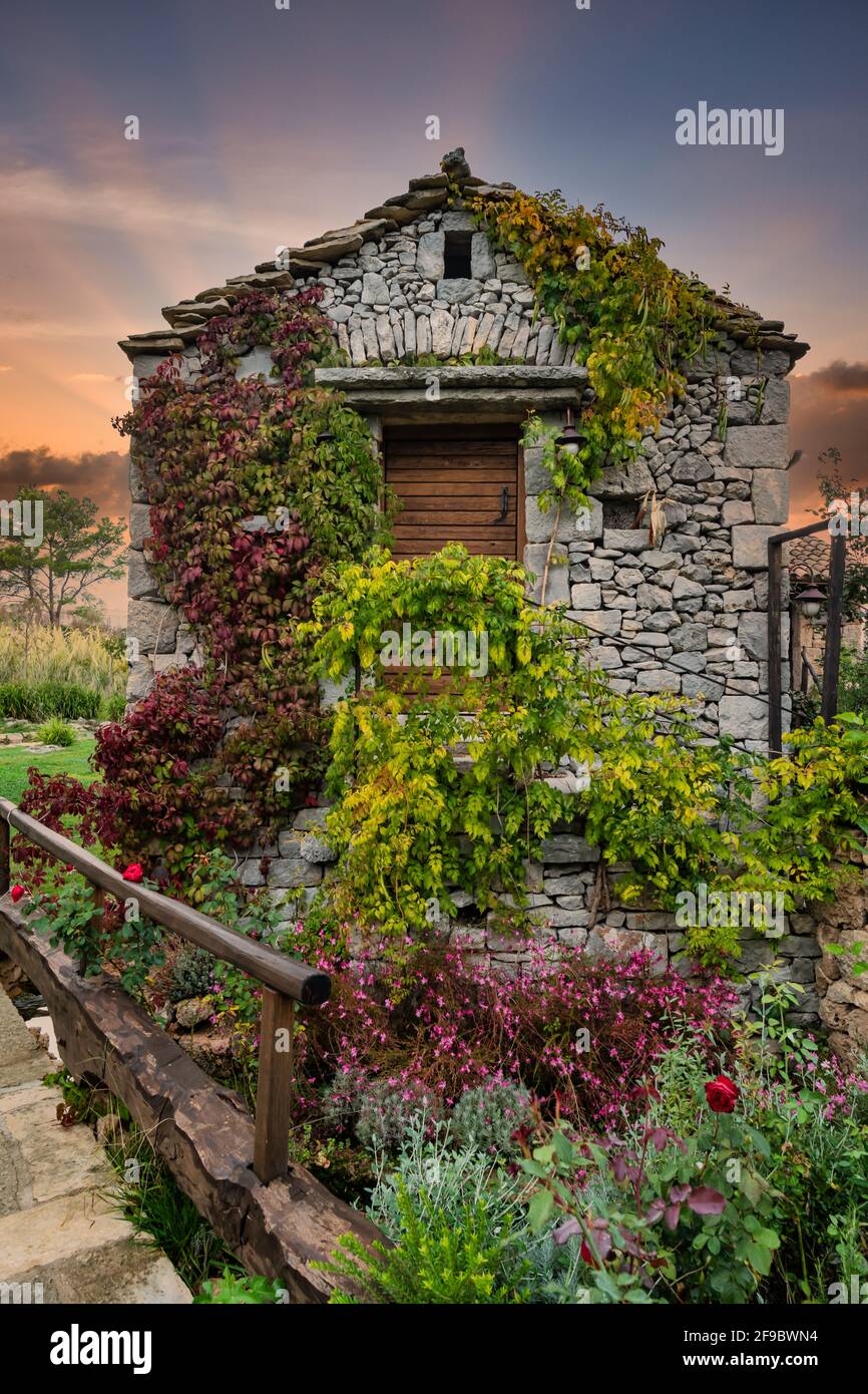Rustic and traditional old stone antique house decorated with flowers ...