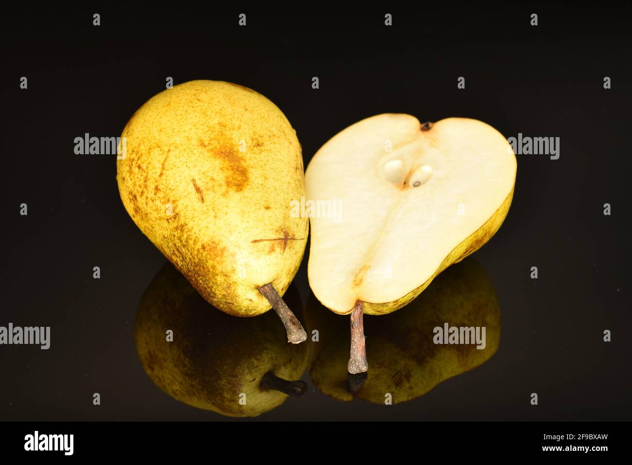 Two halves, cut along a pear, close-up, on a black background Stock ...