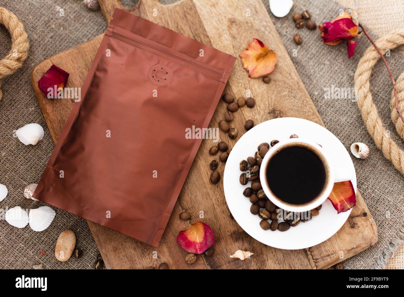 Blank coffee packaging on a wooden board, coffee seeds, cup with coffee ...