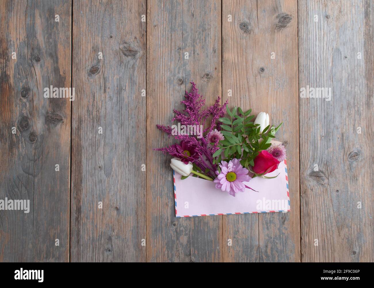 Spring flowers inside a vintage envelope on wooden background Stock ...