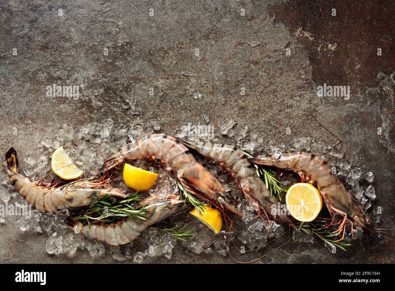 Fresh tiger prawns with lemon, rosemary and crushed ice, top view with ...