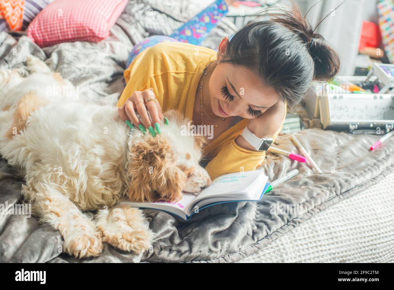 Gen Z writing in her journal with her pet dog Stock Photo - Alamy