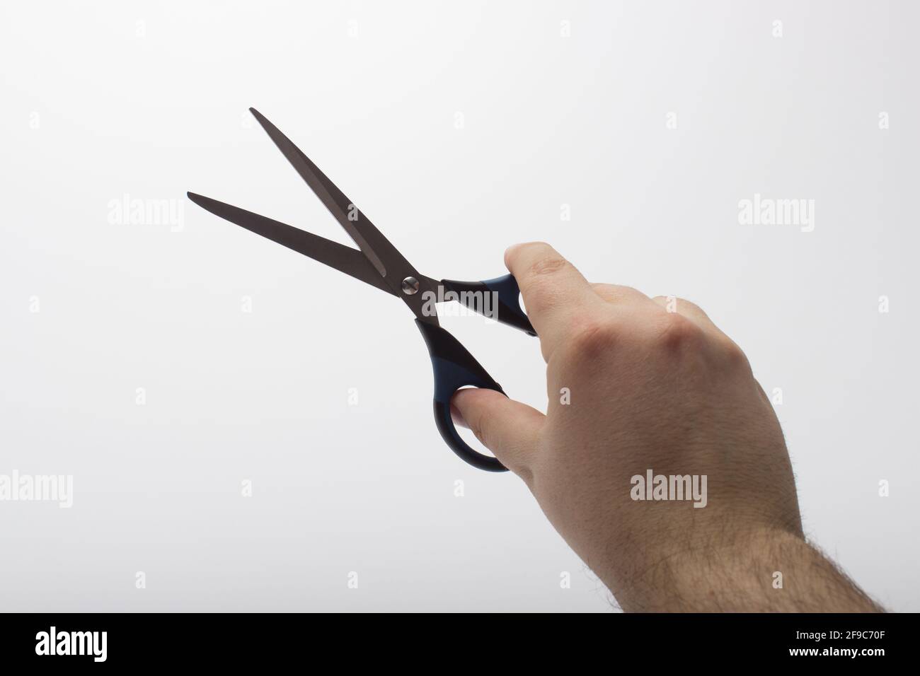 Hand is holding a scissors isolated on a white background. Stationery ...
