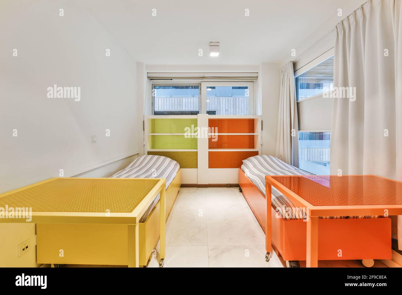 Colorful beds and tables in light room Stock Photo - Alamy