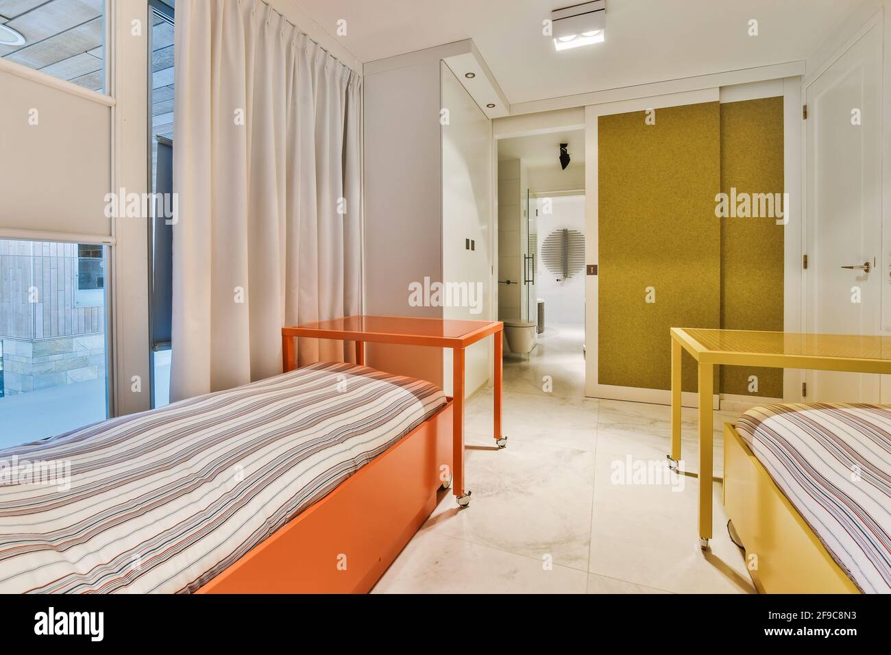Colorful beds in light bedroom Stock Photo - Alamy