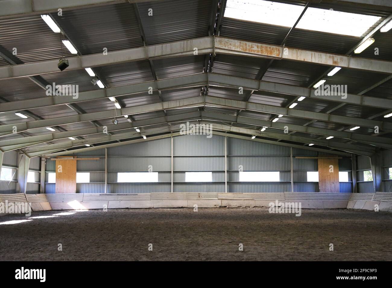 Photo of an empty indoor riding hall for horses and riders. The riding ...