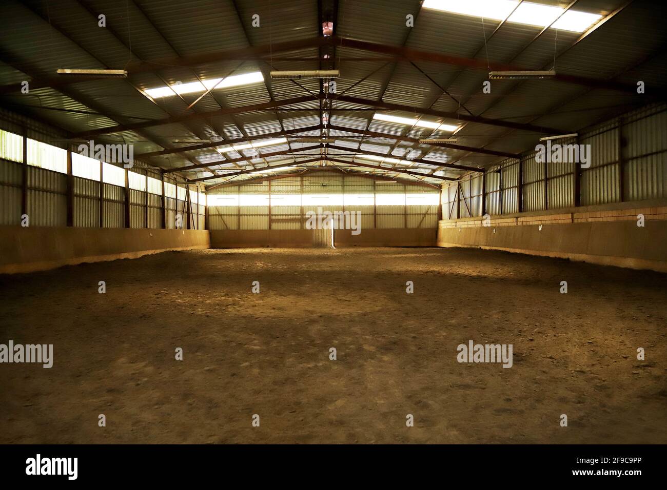 Photo of an empty indoor riding hall for horses and riders. The riding ...