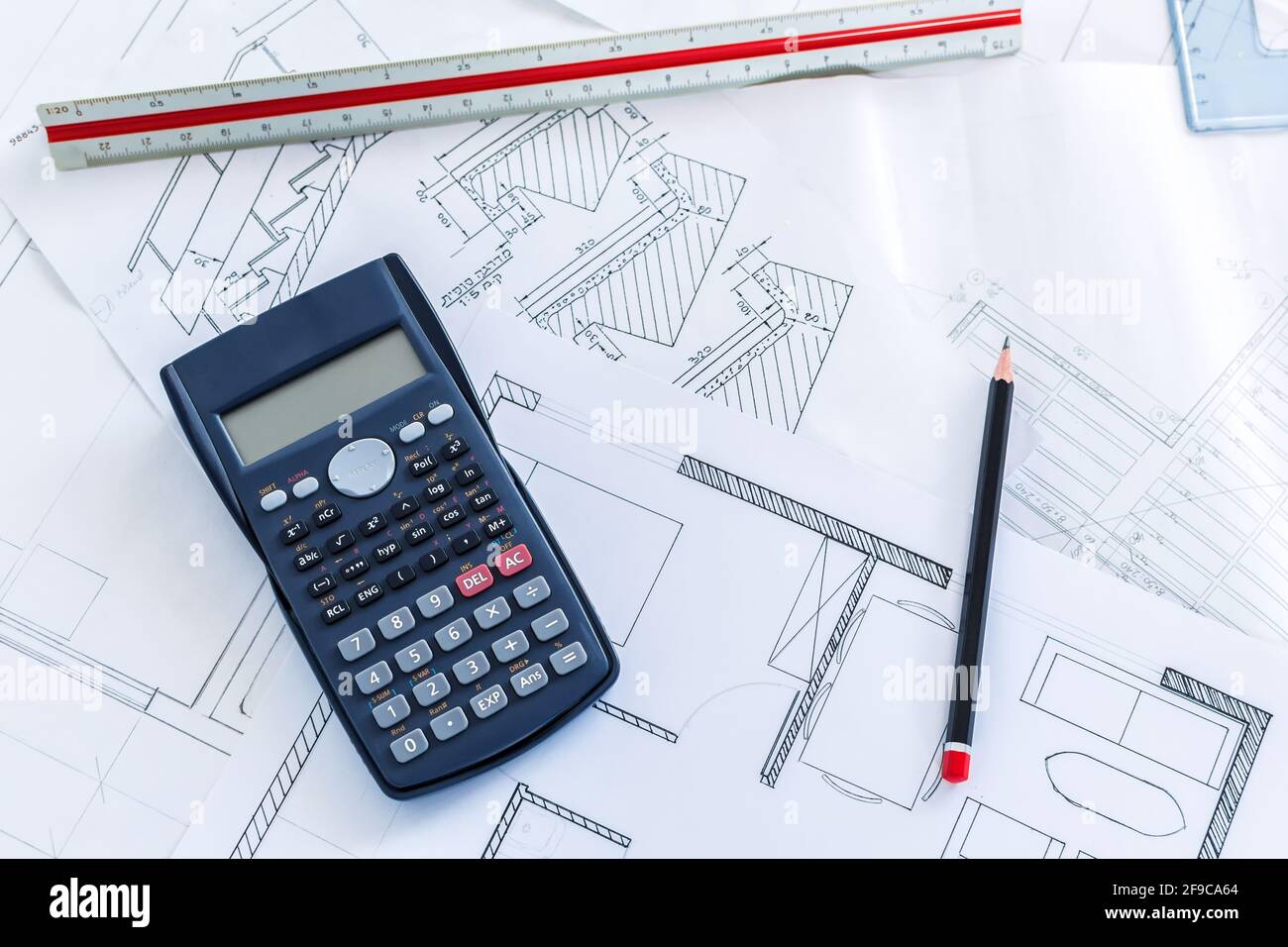 Top view of a scientific calculator on construction blueprints and ...