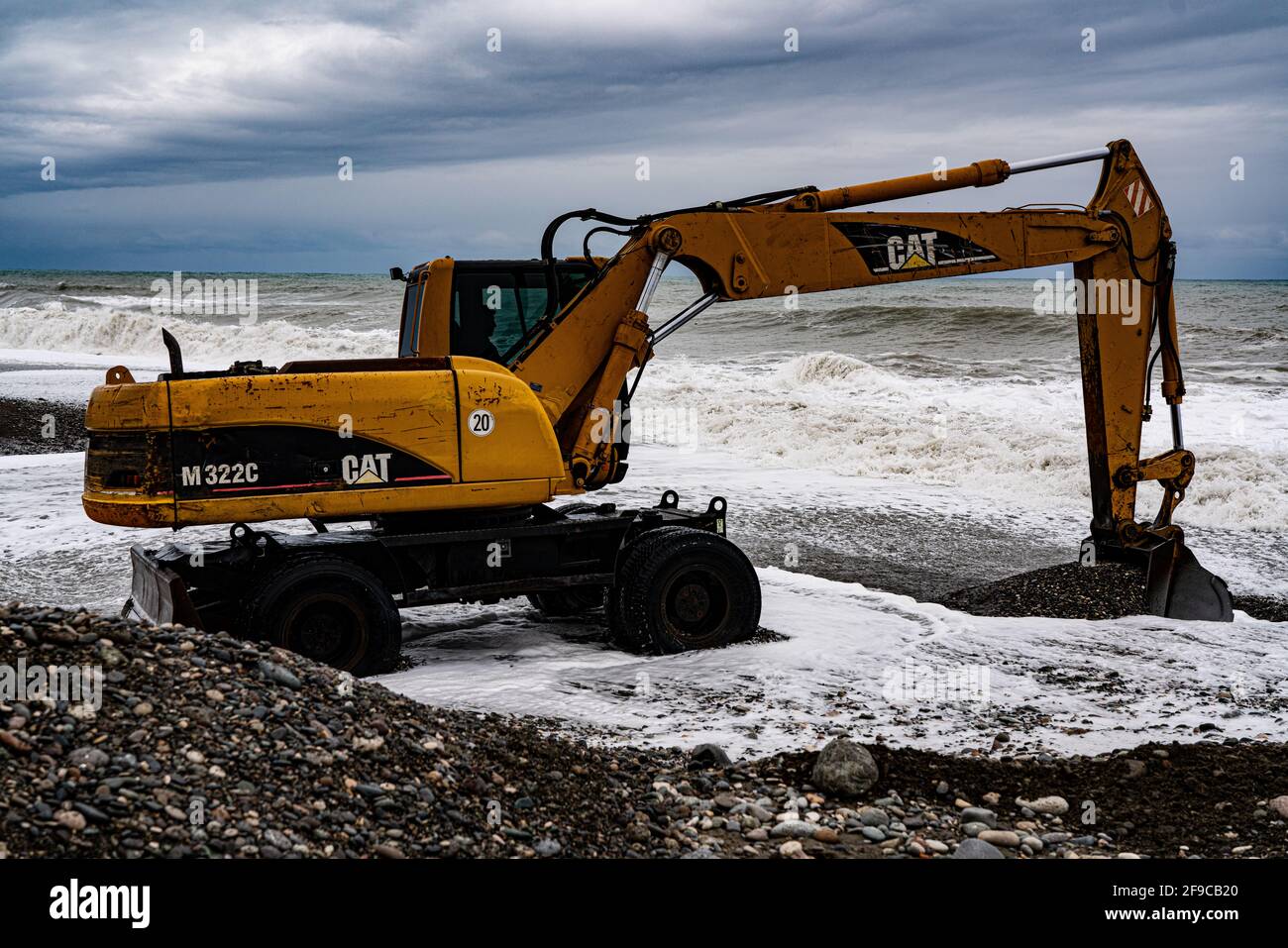 yellow excavator digging the seashore Stock Photo - Alamy