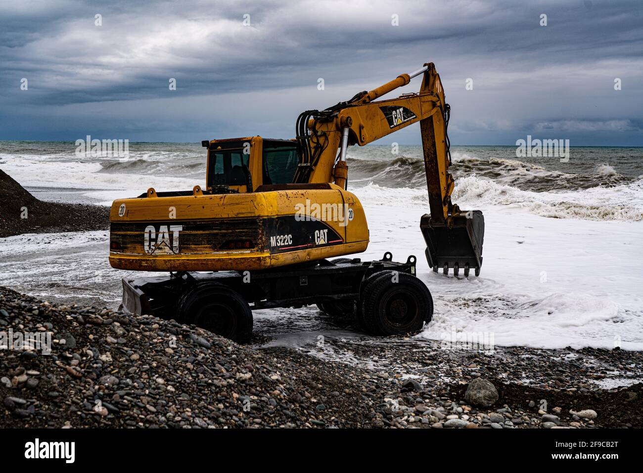 yellow excavator digging the seashore Stock Photo - Alamy