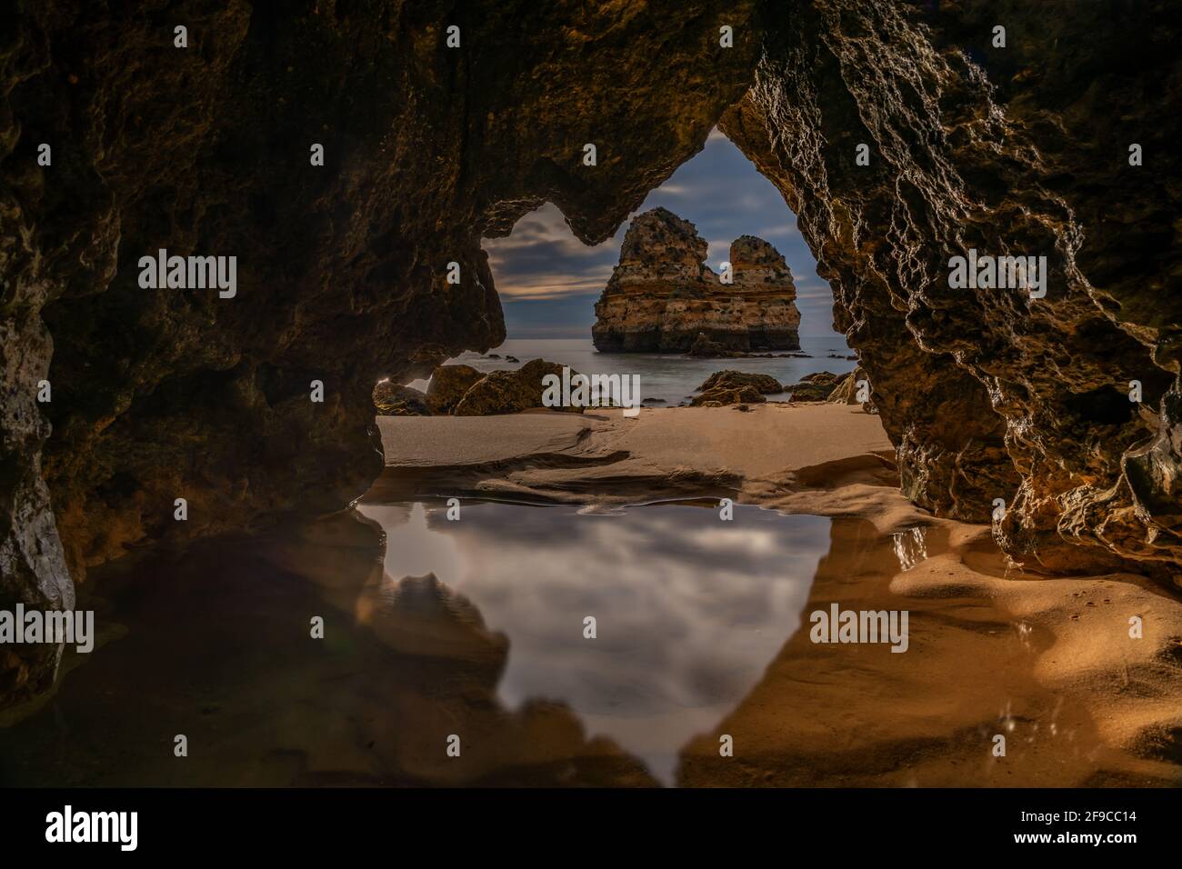 Beautiful view of the rocks and the cave in the puddle reflection near ...