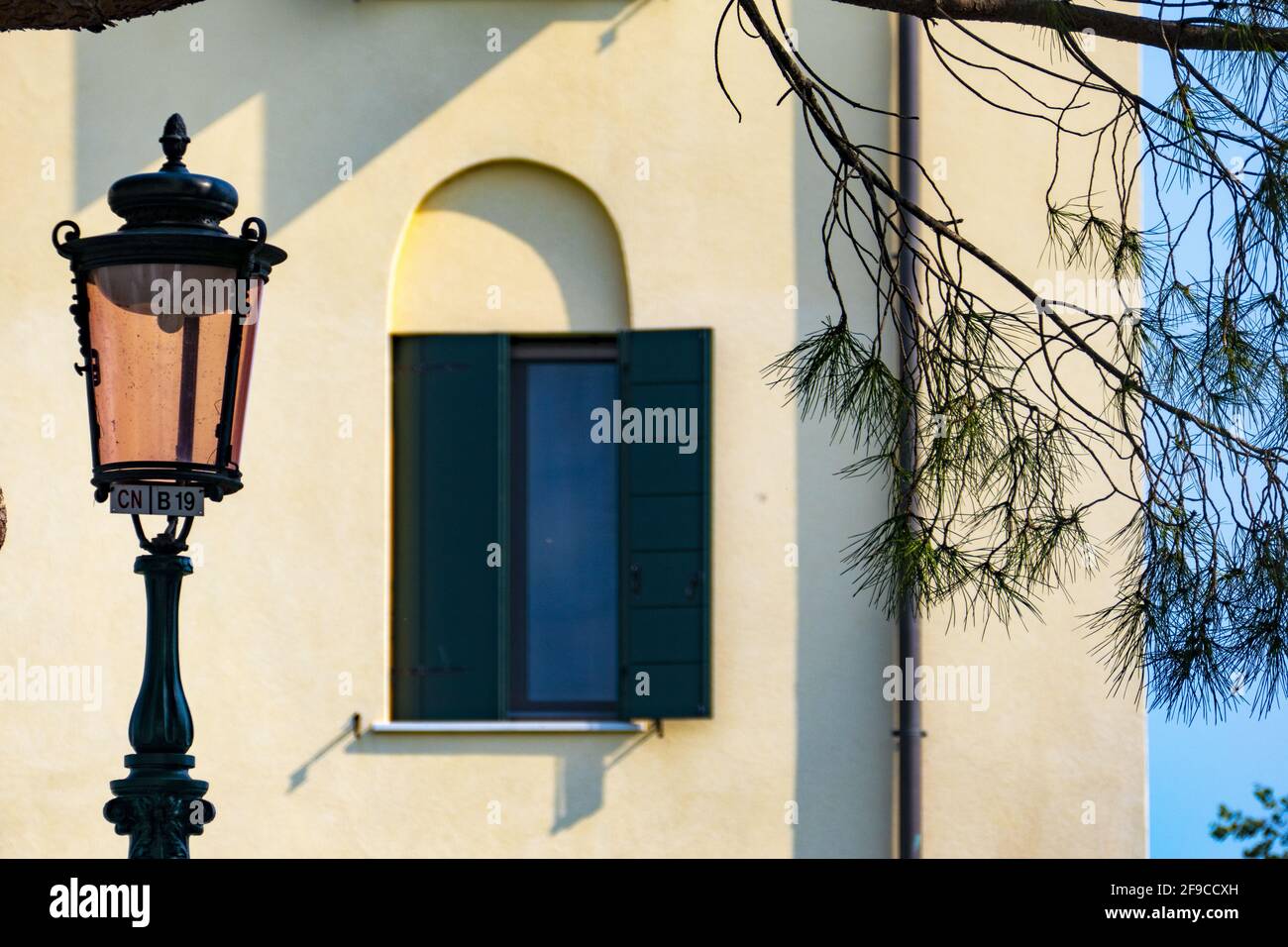 Street lamp against a building with light yellow exterior walls and a ...