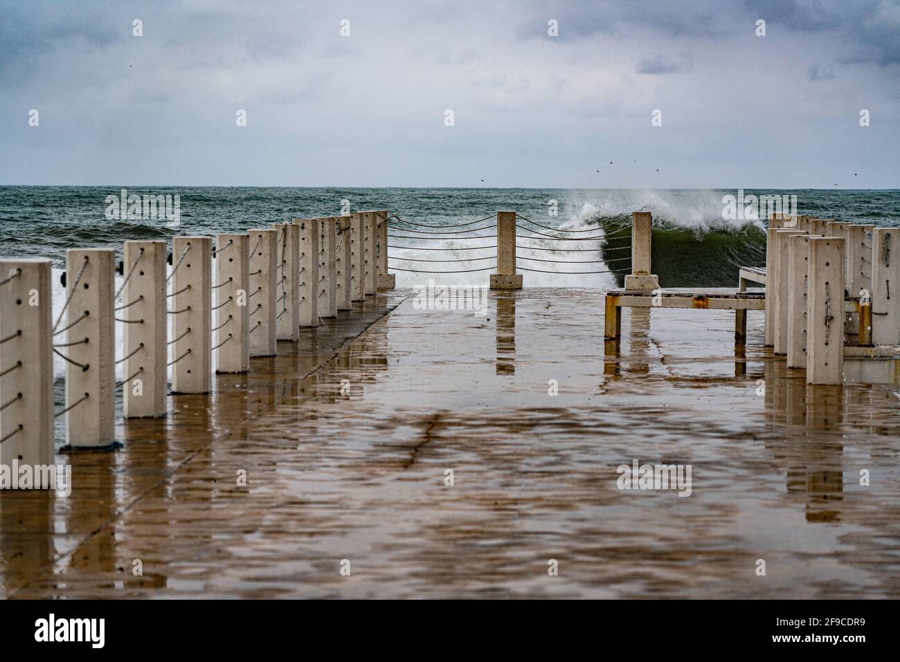 waves roll on the pier during a storm Stock Photo - Alamy