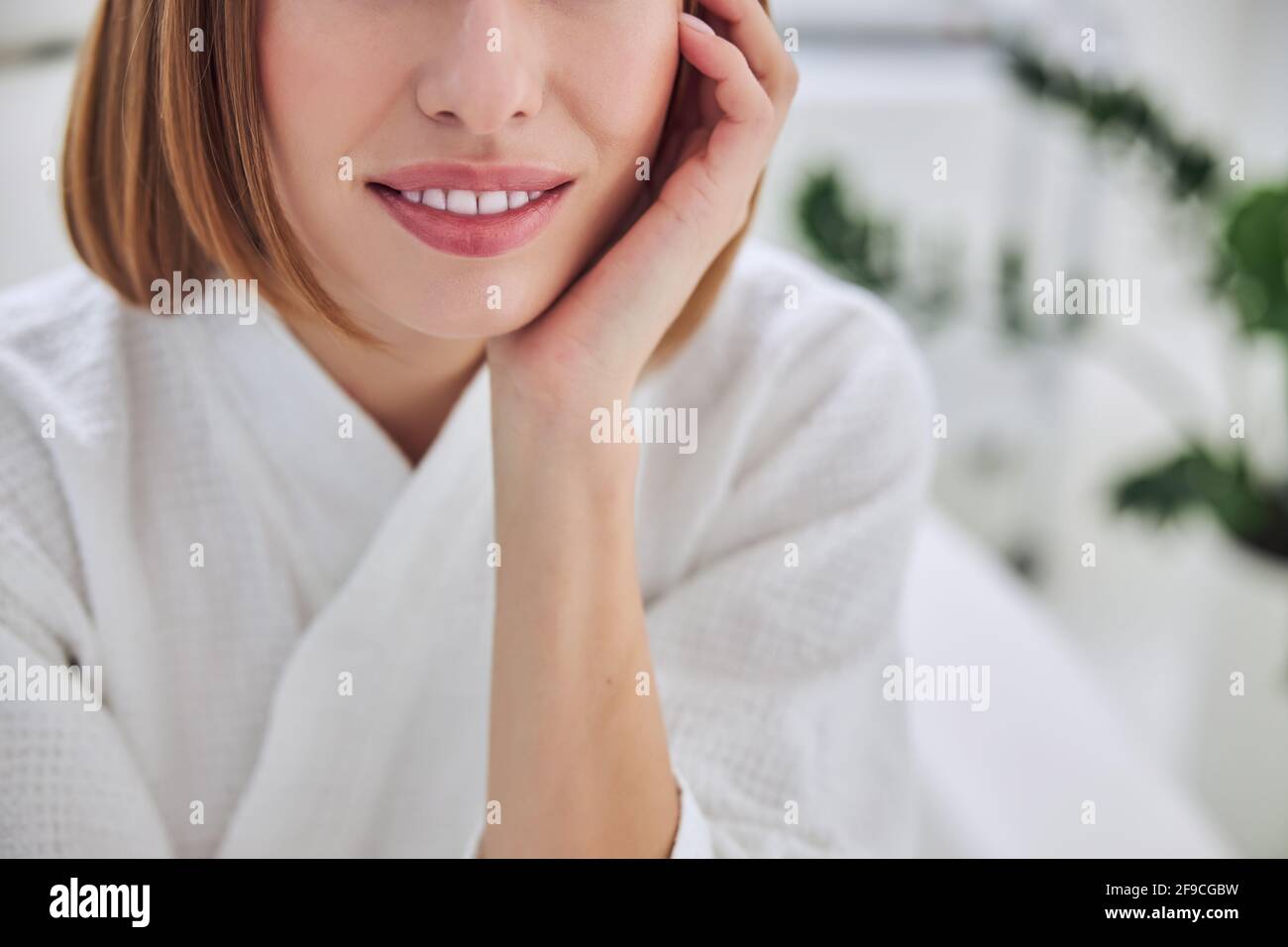Happy cheerful woman in white clothes relaxing in spa resort hotel ...