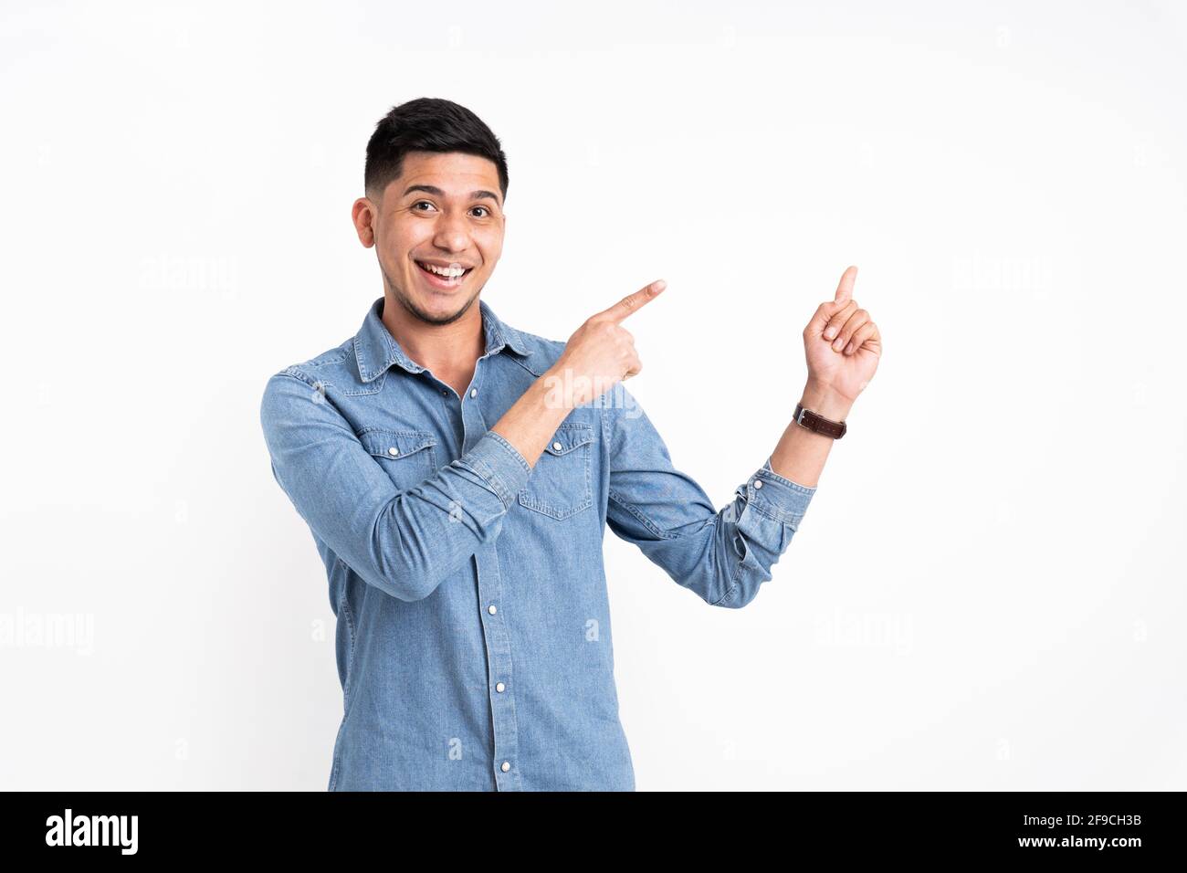 Caucasian man pointing his two fingers to the side and smiling at the ...