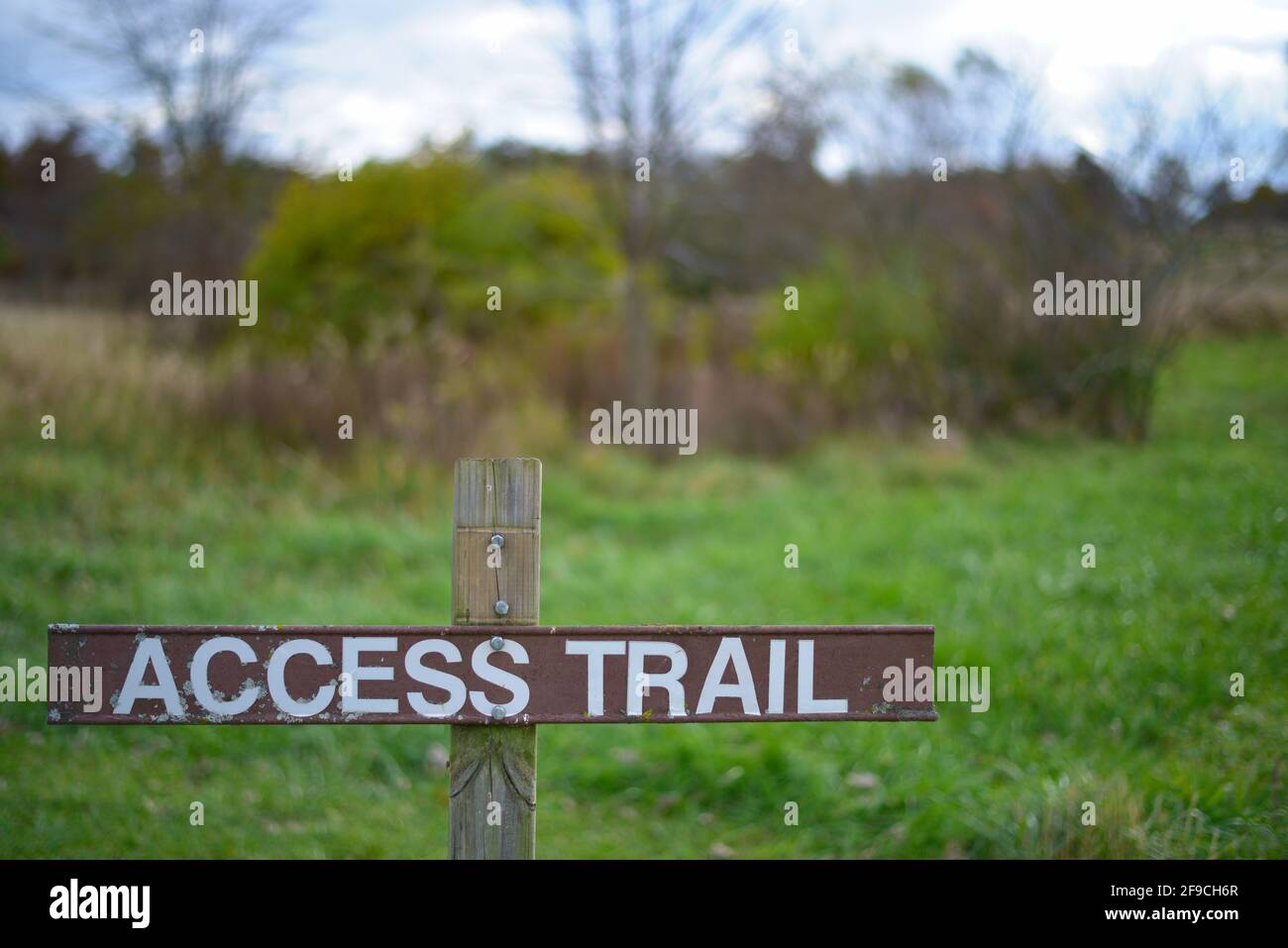 Wooden sign board informing about access trail in nature Stock Photo ...