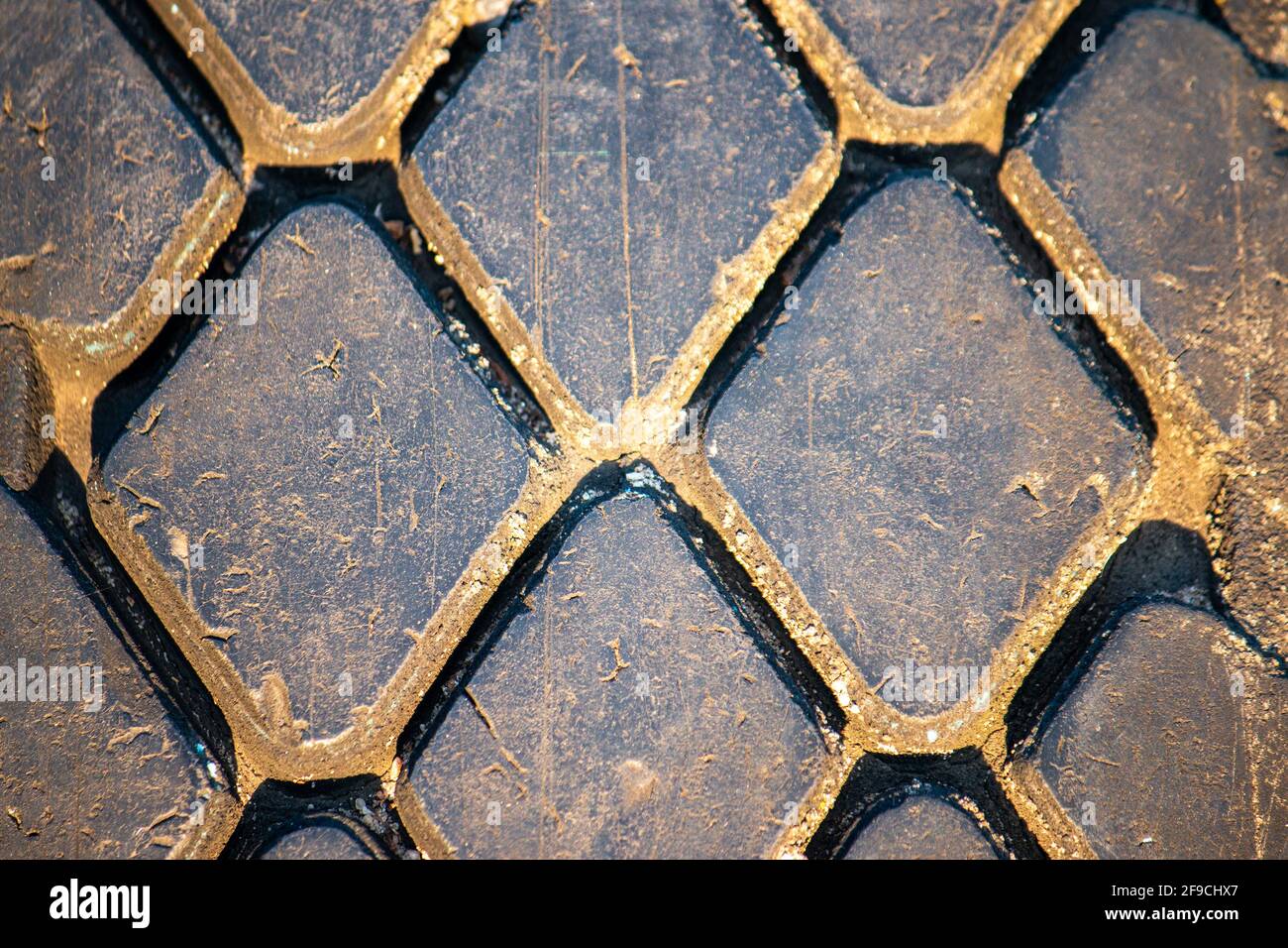 Diamond-shaped dirty tread track of an off-road car tire in warm colors ...