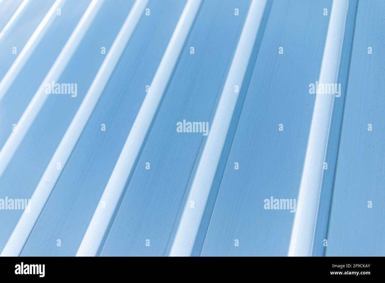 Perspective of a shining reflective gray-blue metal panel striped wall ...