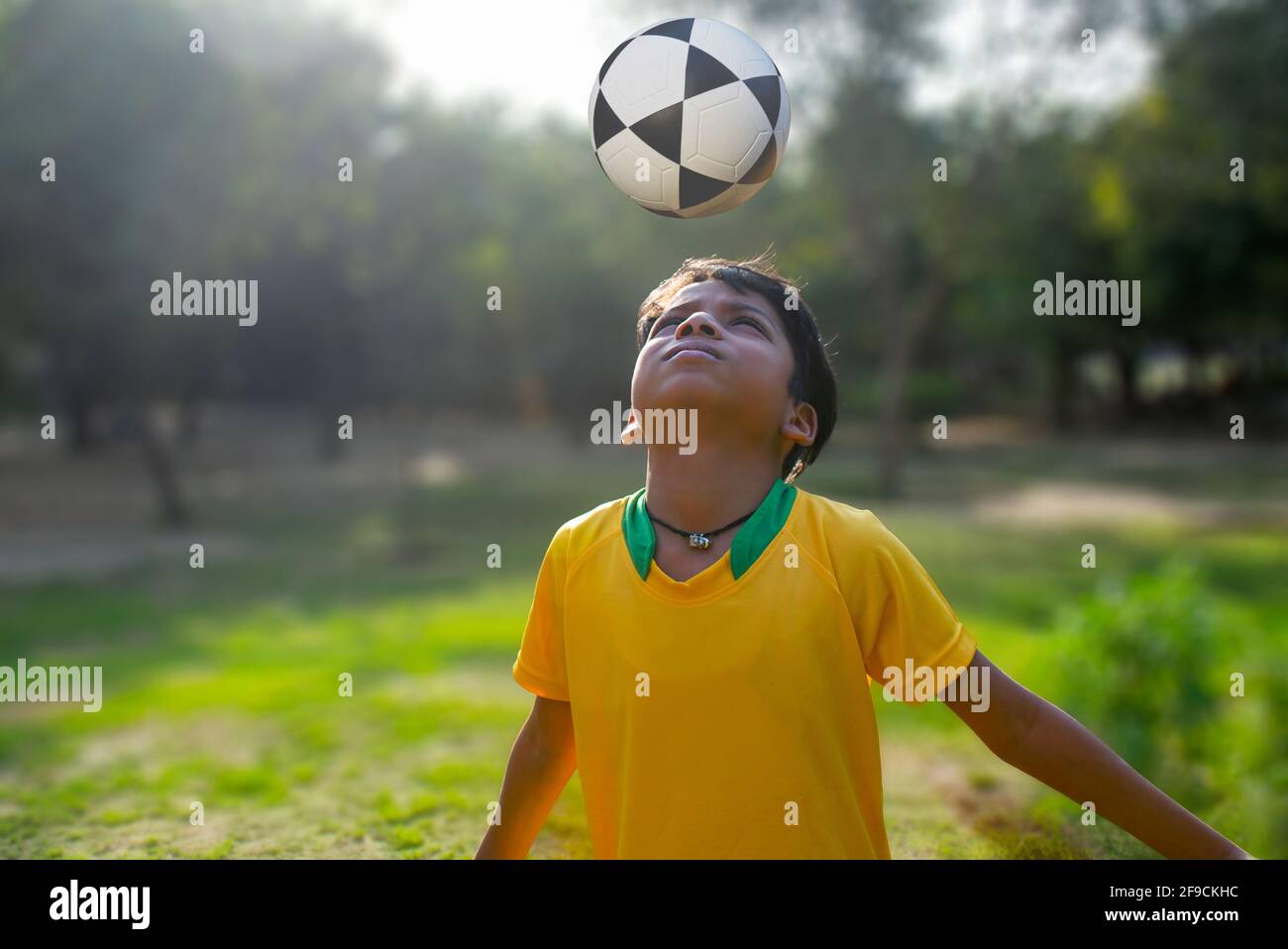 Portrait of boy heading football Stock Photo - Alamy