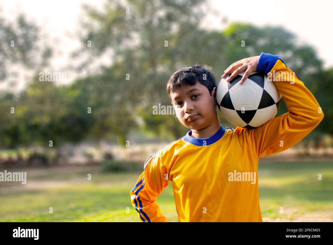 Portrait Of A Young Boy Holding A Football On His Shoulder Stock Photo ...