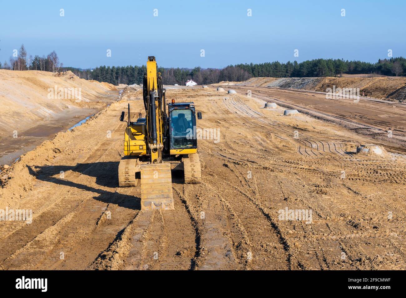 Excavator on a highway construction site. Road construction work Stock ...