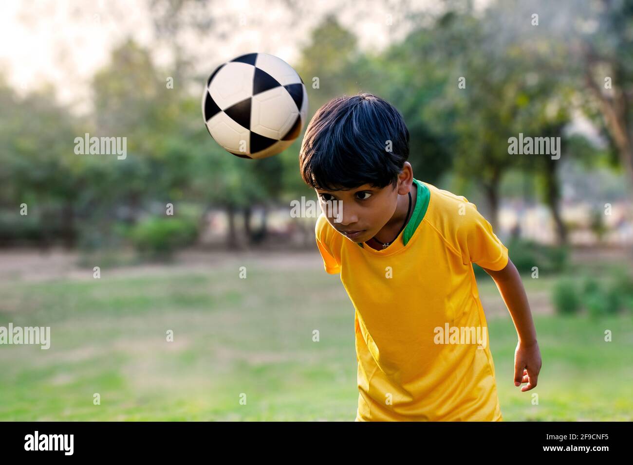 Portrait of boy heading football Stock Photo - Alamy