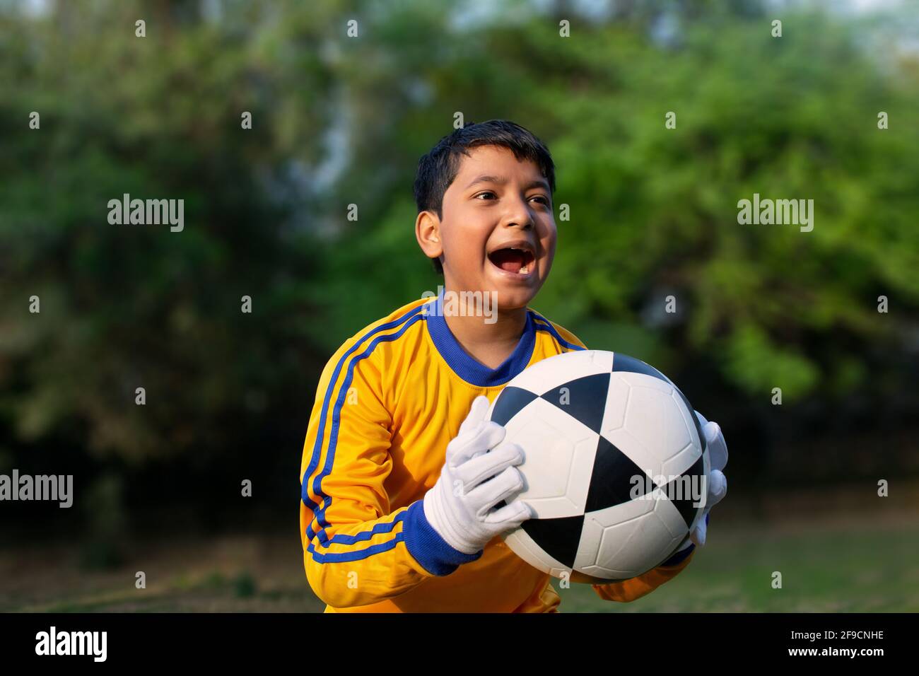 Excited boy football player Holding scored ball Stock Photo - Alamy
