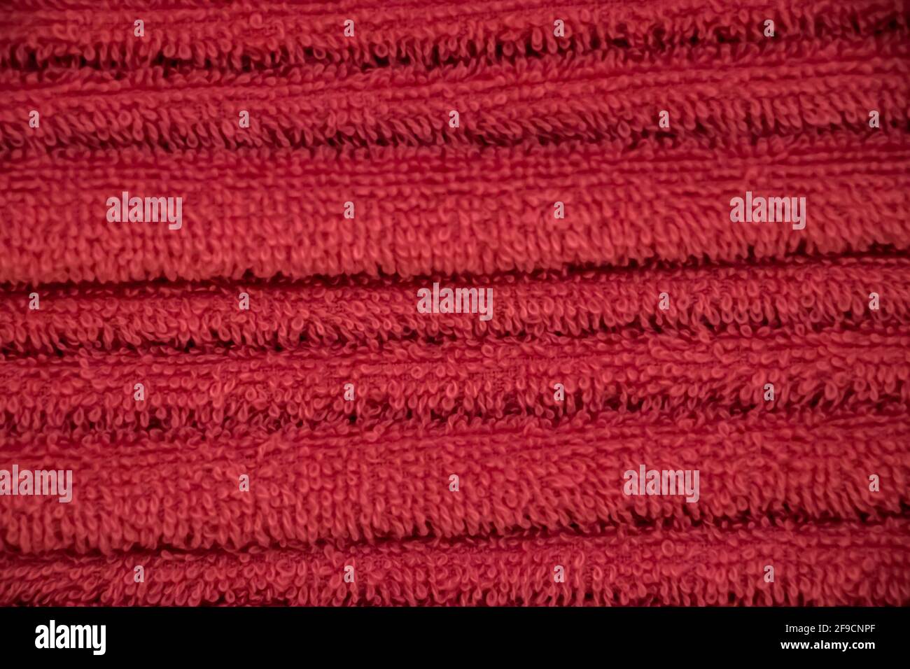 Red texture of terry towel close-up. A stack of soft bath accessories ...