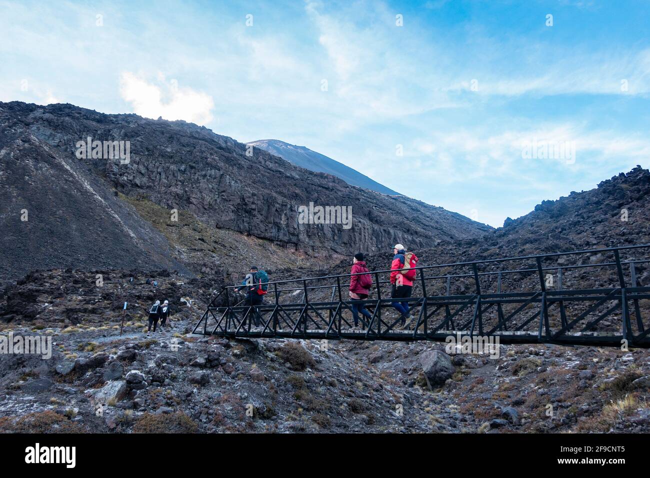 Tongariro New Zealand - March 27 2021; Trampers cross small bridge in ...