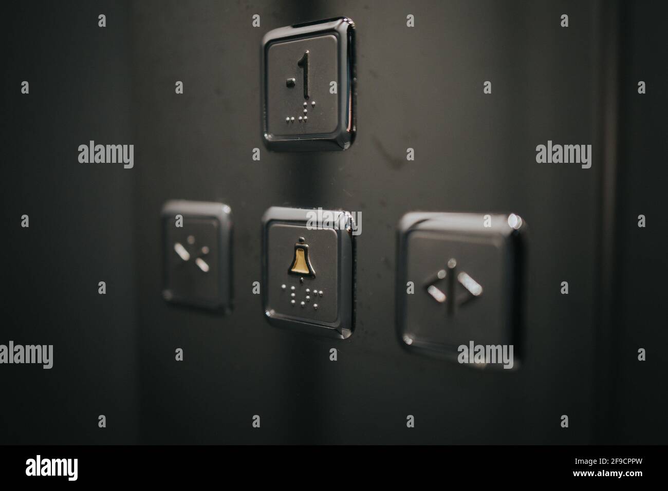 Closeup of elevator metal buttons - "-1", "open door", "alert", and ...