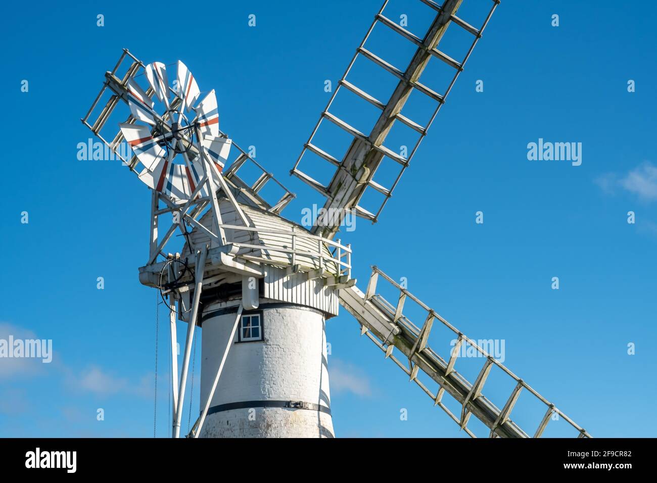 Fantail and sails on the cap of a traditional white windmill in the ...